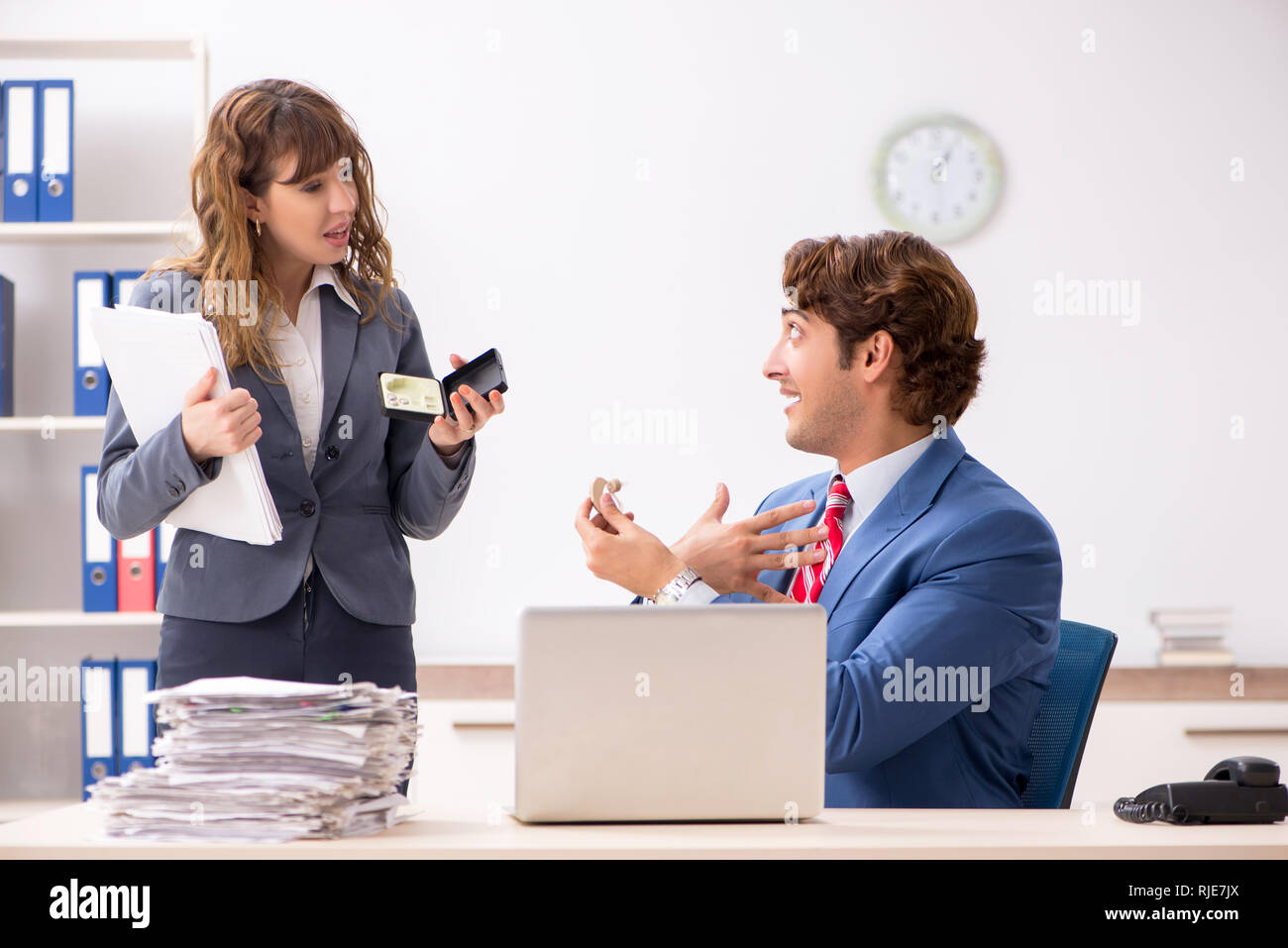 Deaf employee using hearing aid talking to boss Stock Photo - Alamy
