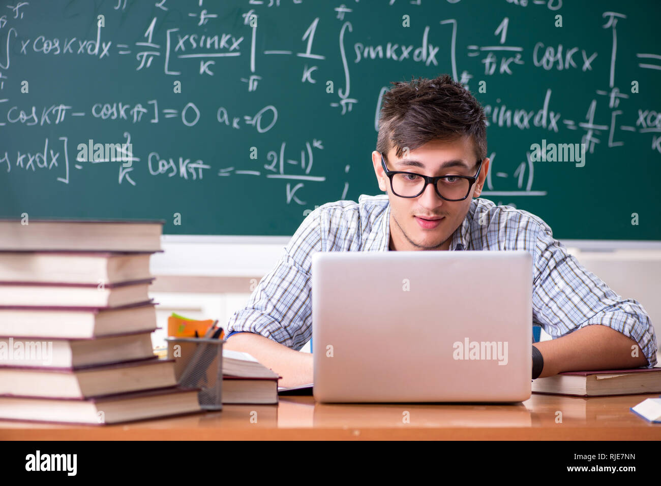 Young male student studying math at school Stock Photo - Alamy