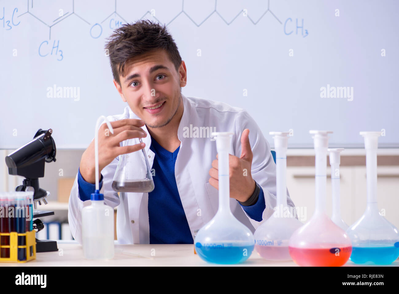 Happy young chemist mixing hi-res stock photography and images - Alamy