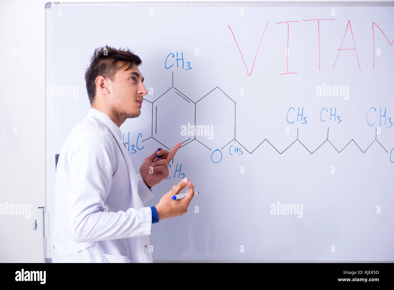 Young chemist standing in front of the whiteboard Stock Photo - Alamy