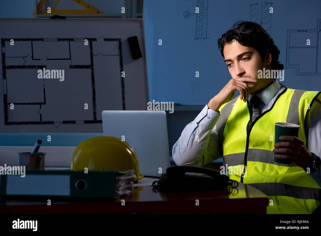 Young construction architect working on project at night Stock Photo ...