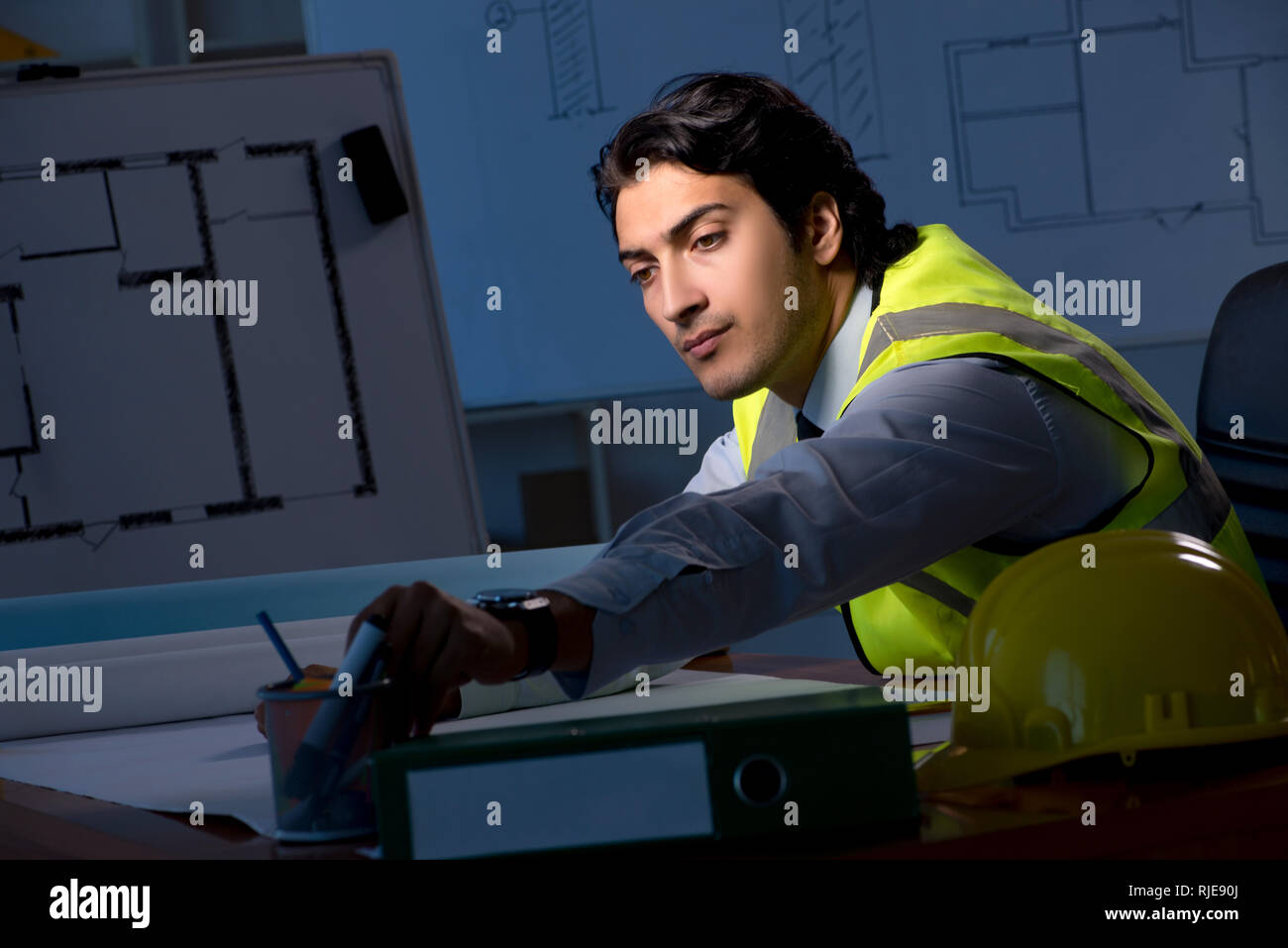 Young construction architect working on project at night Stock Photo ...