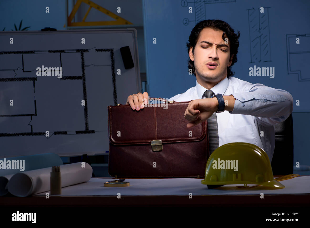 Young construction architect working on project at night Stock Photo ...