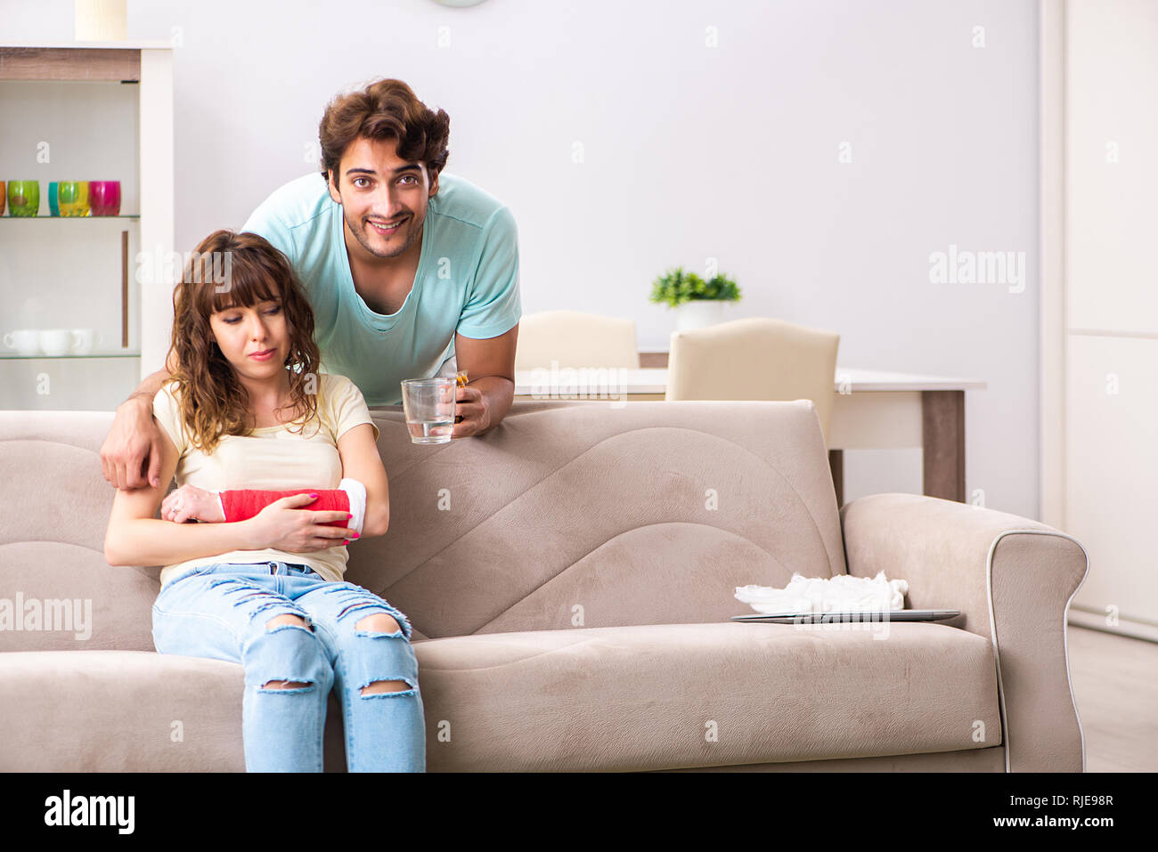 Young family helping each other after injury Stock Photo - Alamy