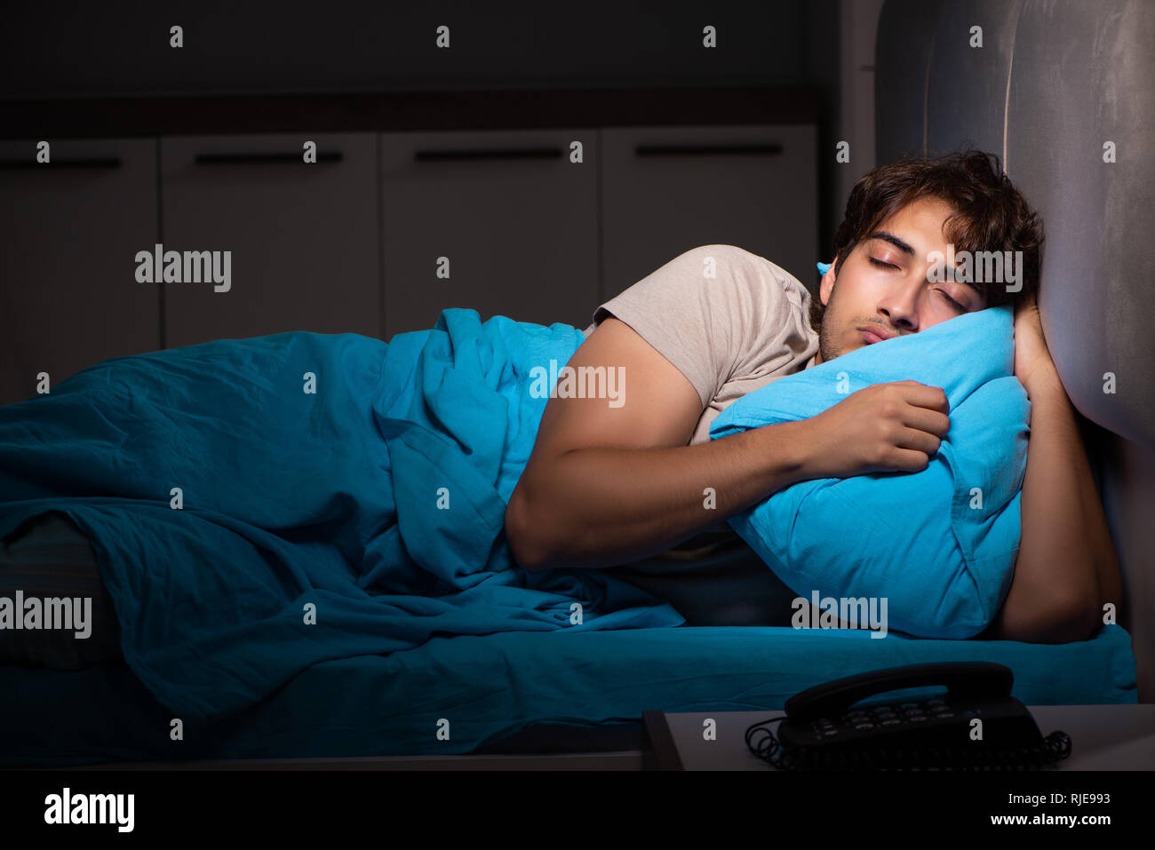 Tired exhausted man sleeping in his bed Stock Photo - Alamy