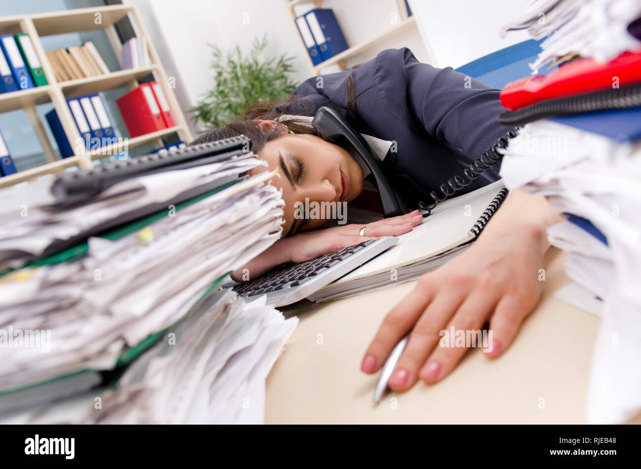 Female employee with too much work in the office Stock Photo - Alamy