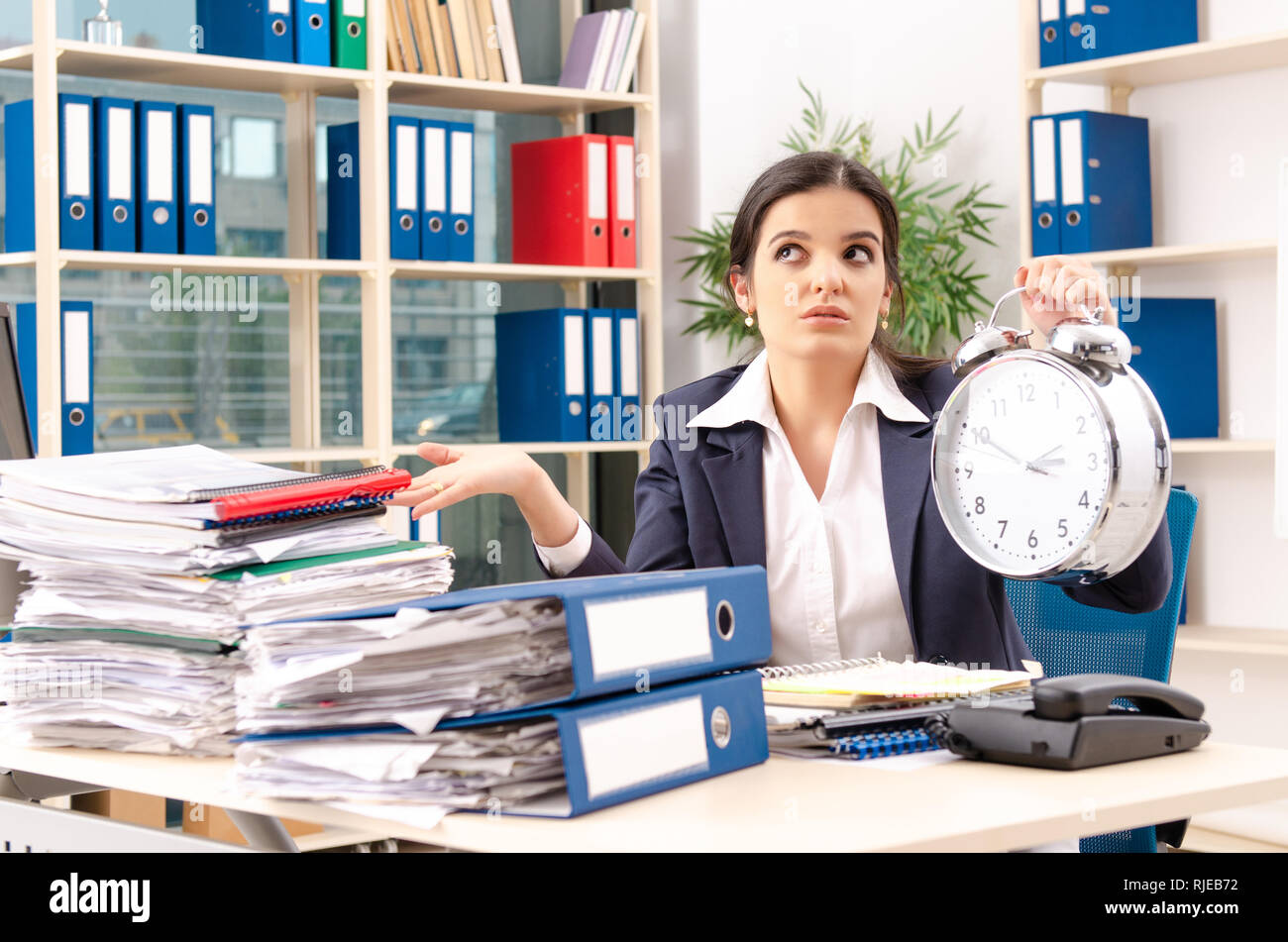 Female employee with too much work in the office Stock Photo - Alamy