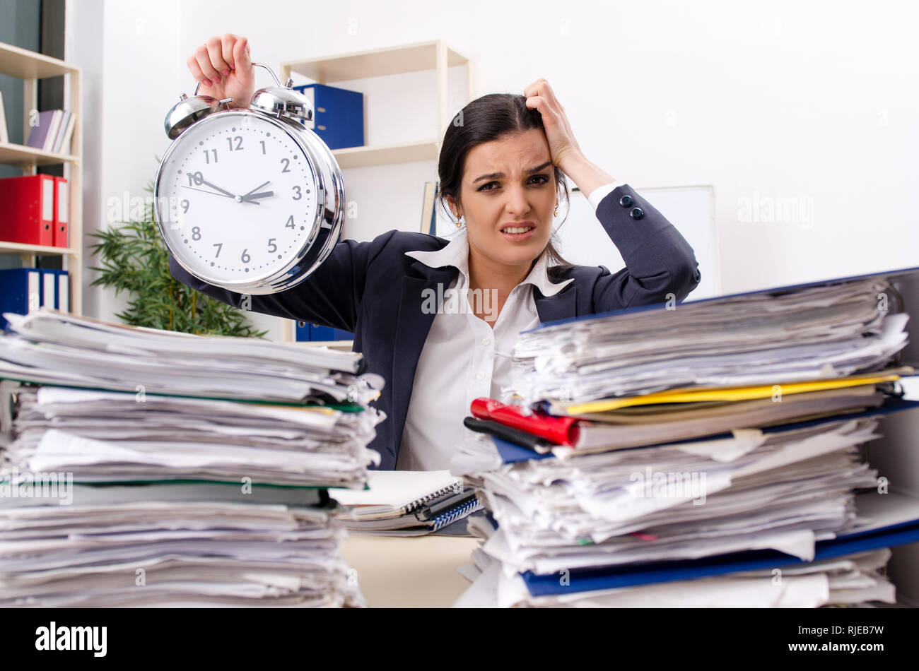 Female employee with too much work in the office Stock Photo - Alamy