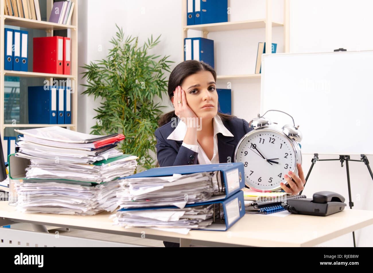 Female employee with too much work in the office Stock Photo - Alamy