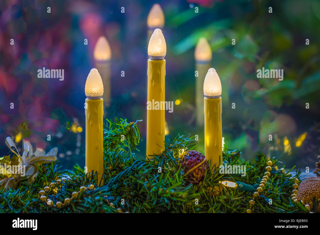 Three Christmas candles in a Christamas decoration Stock Photo - Alamy