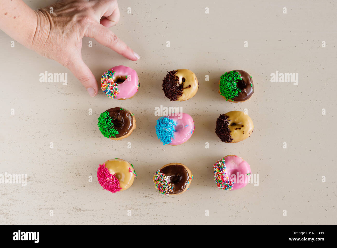 mini donuts in various colours on a plain background Stock Photo - Alamy