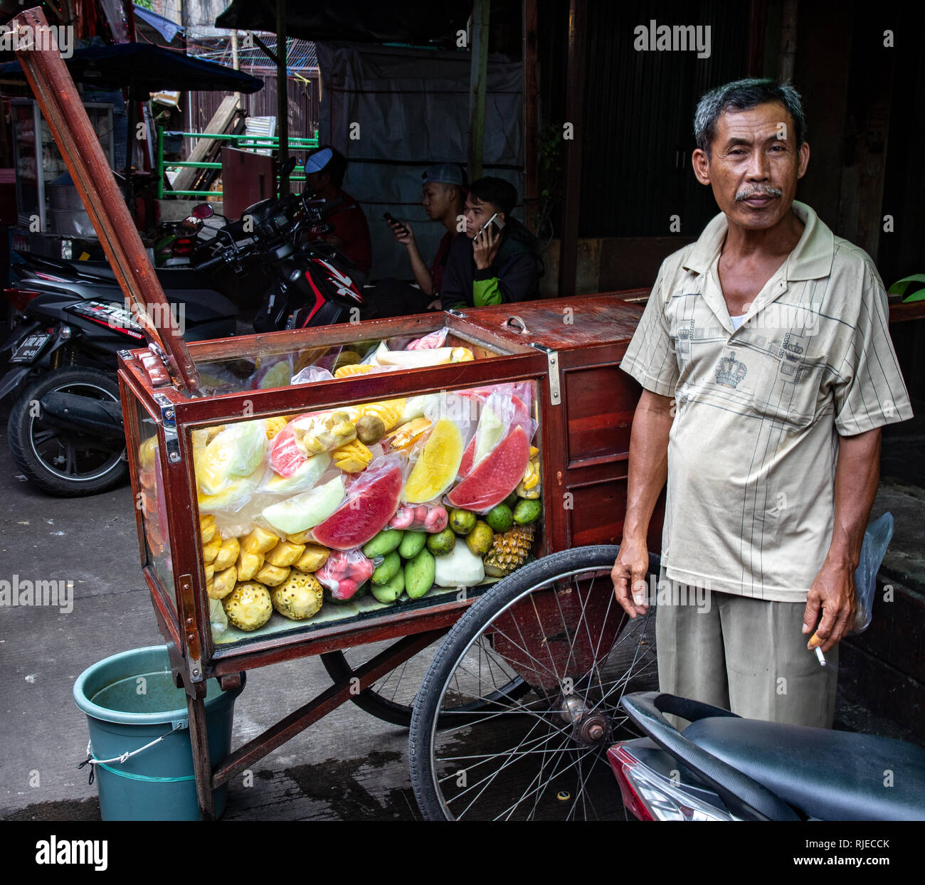 A man sells rijak, a spicy fruit salad, in a traditional Indonesian ...