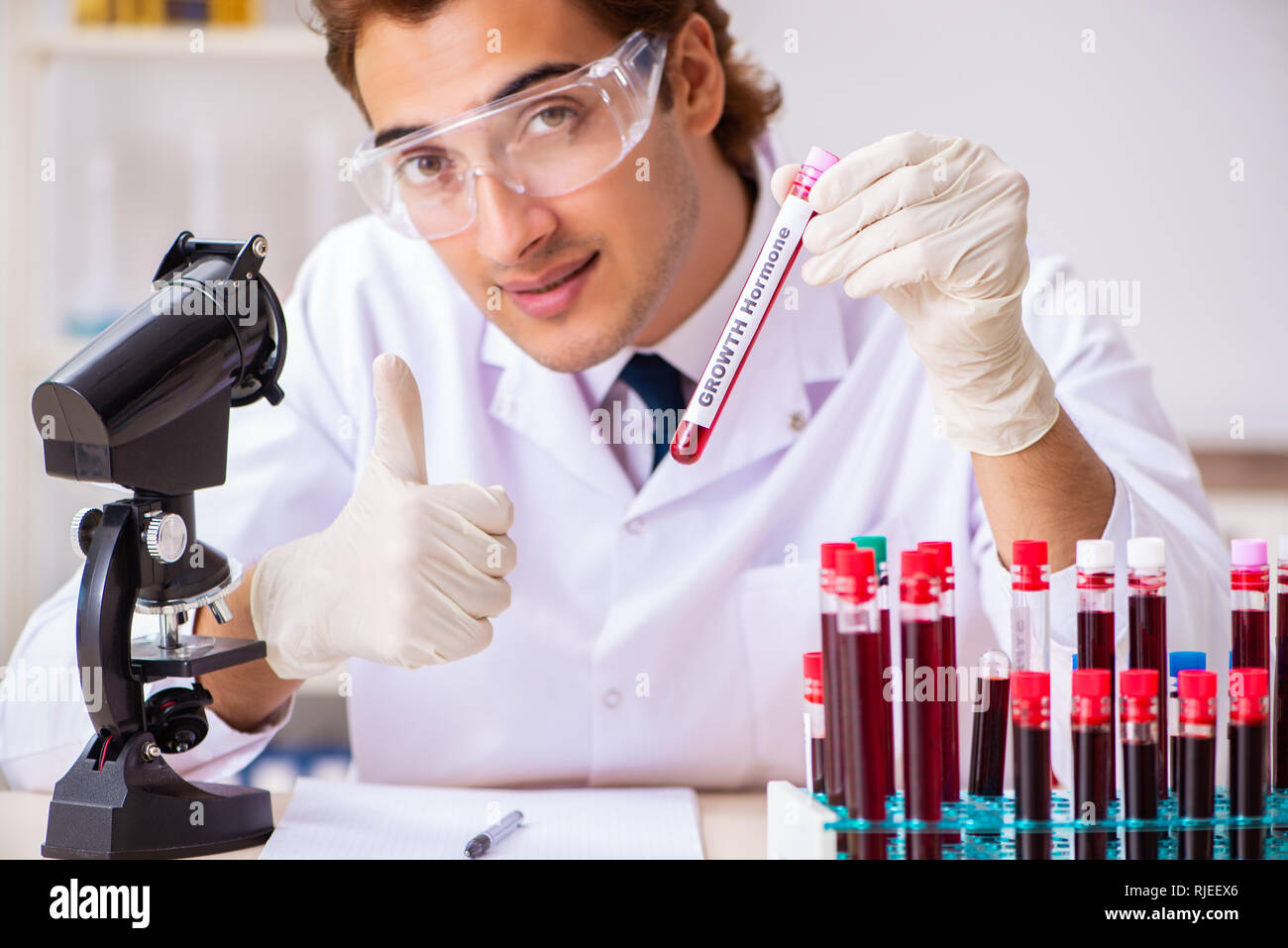 Young handsome lab assistant testing blood samples in hospital Stock ...