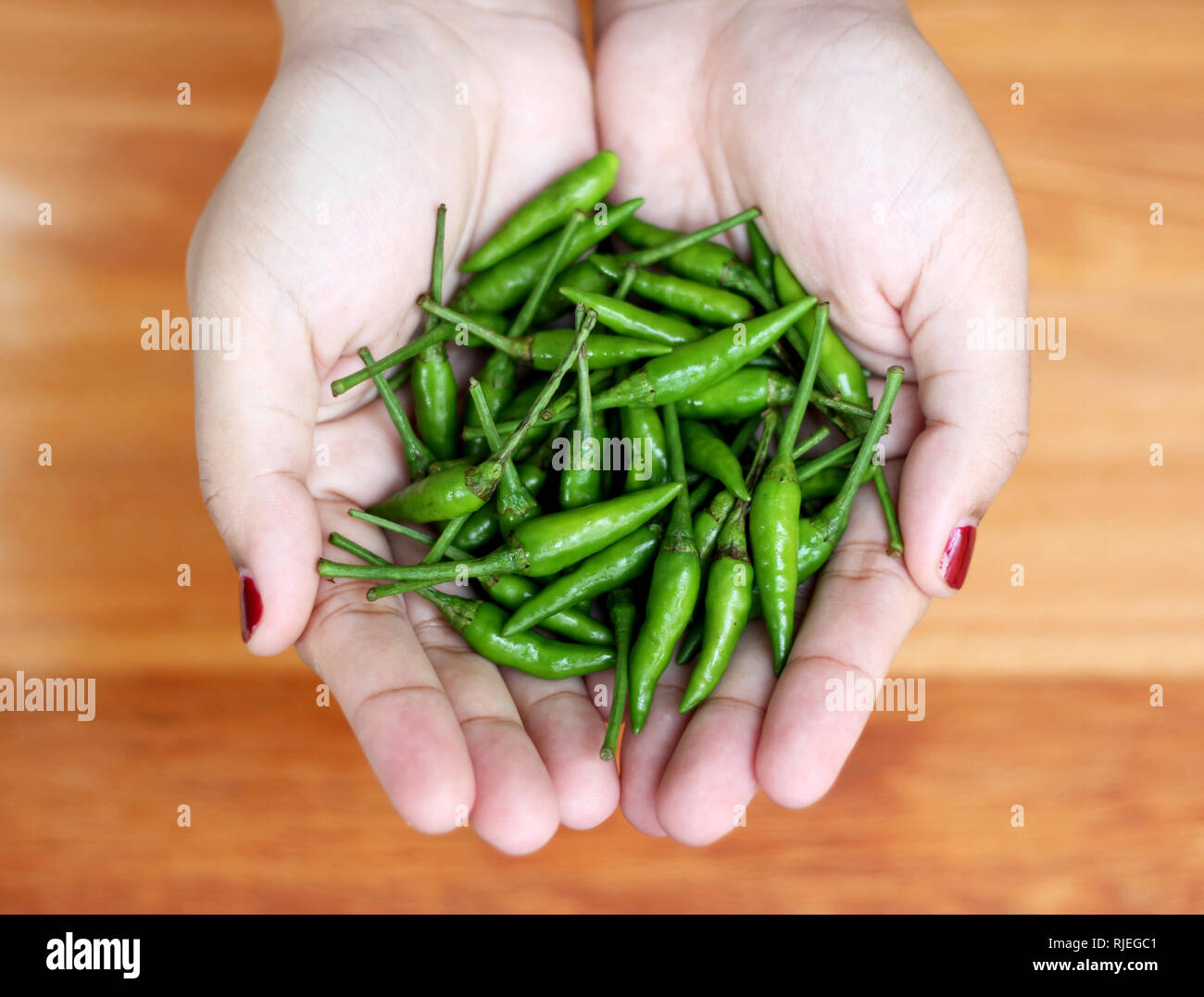 Green Chilli Pepper on Hand Stock Photo - Alamy