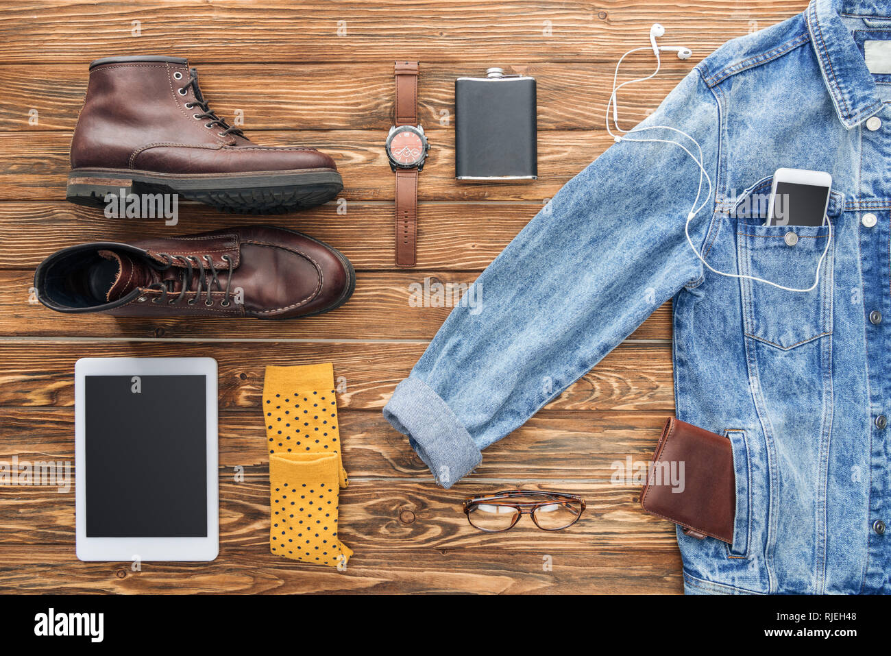 Flat lay of boots, denim jacket and digital devices on wooden ...
