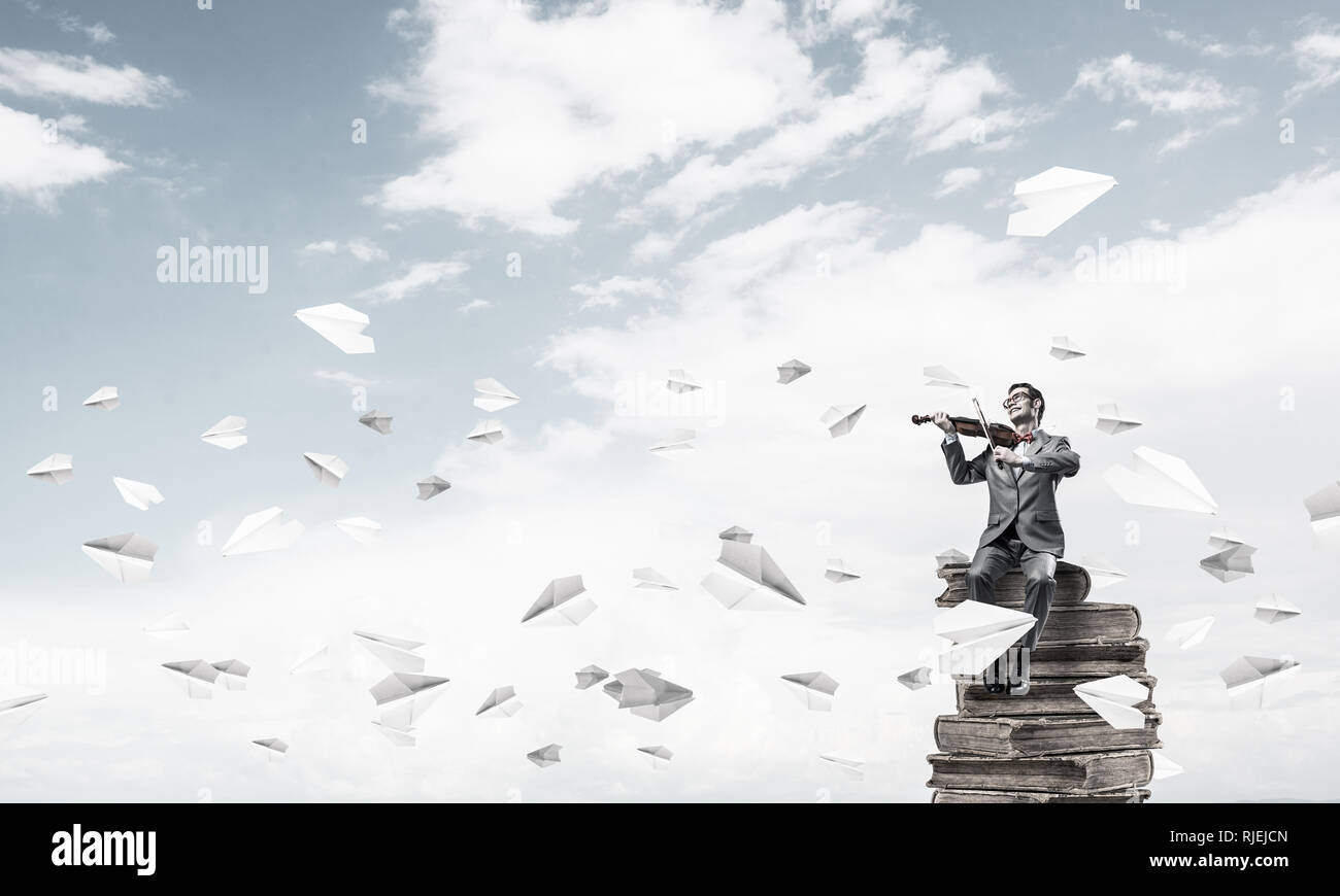 Handsome violinist play his melody and paper planes fly around Stock ...