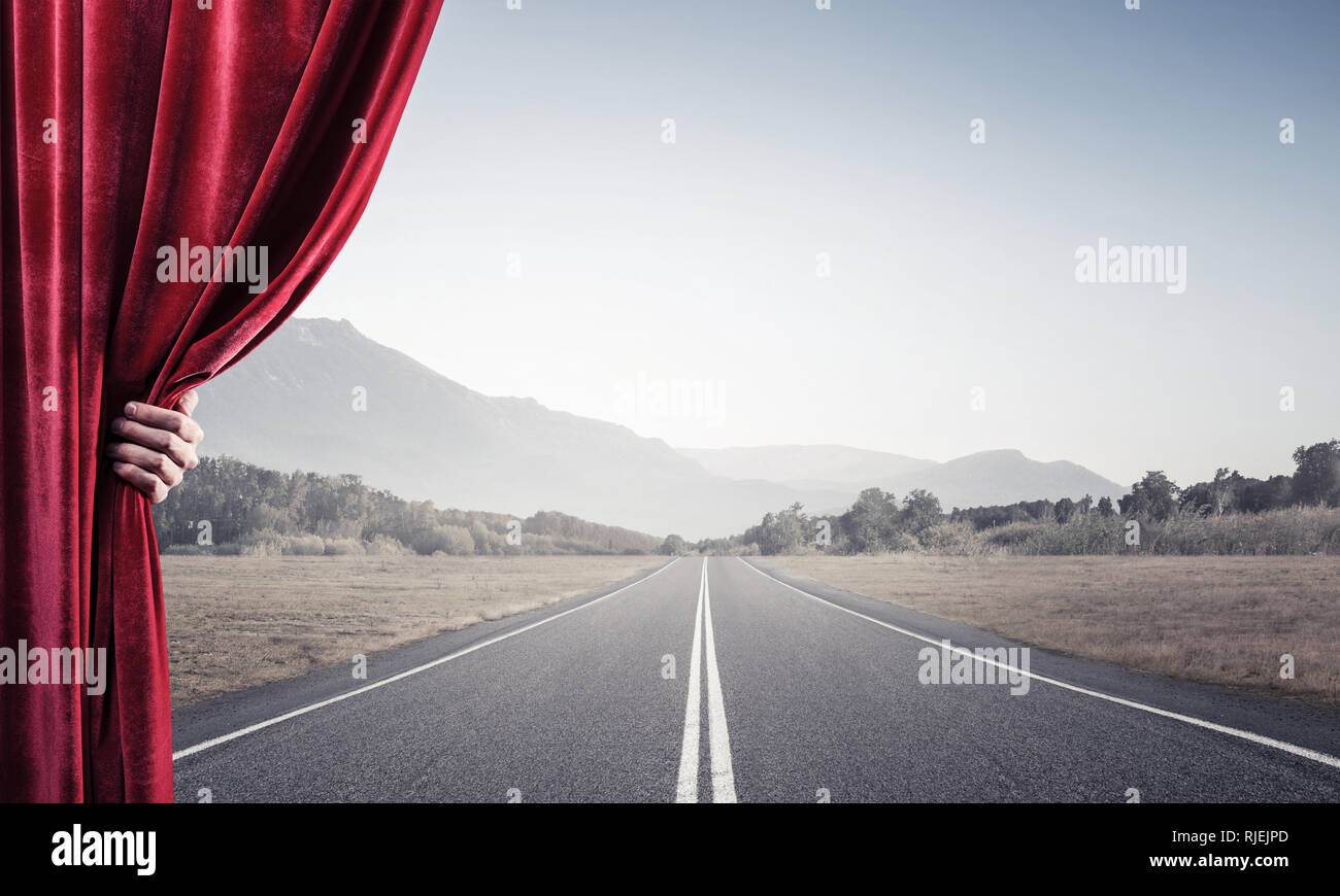 Asphalt road behind red curtain and hand holding it Stock Photo - Alamy