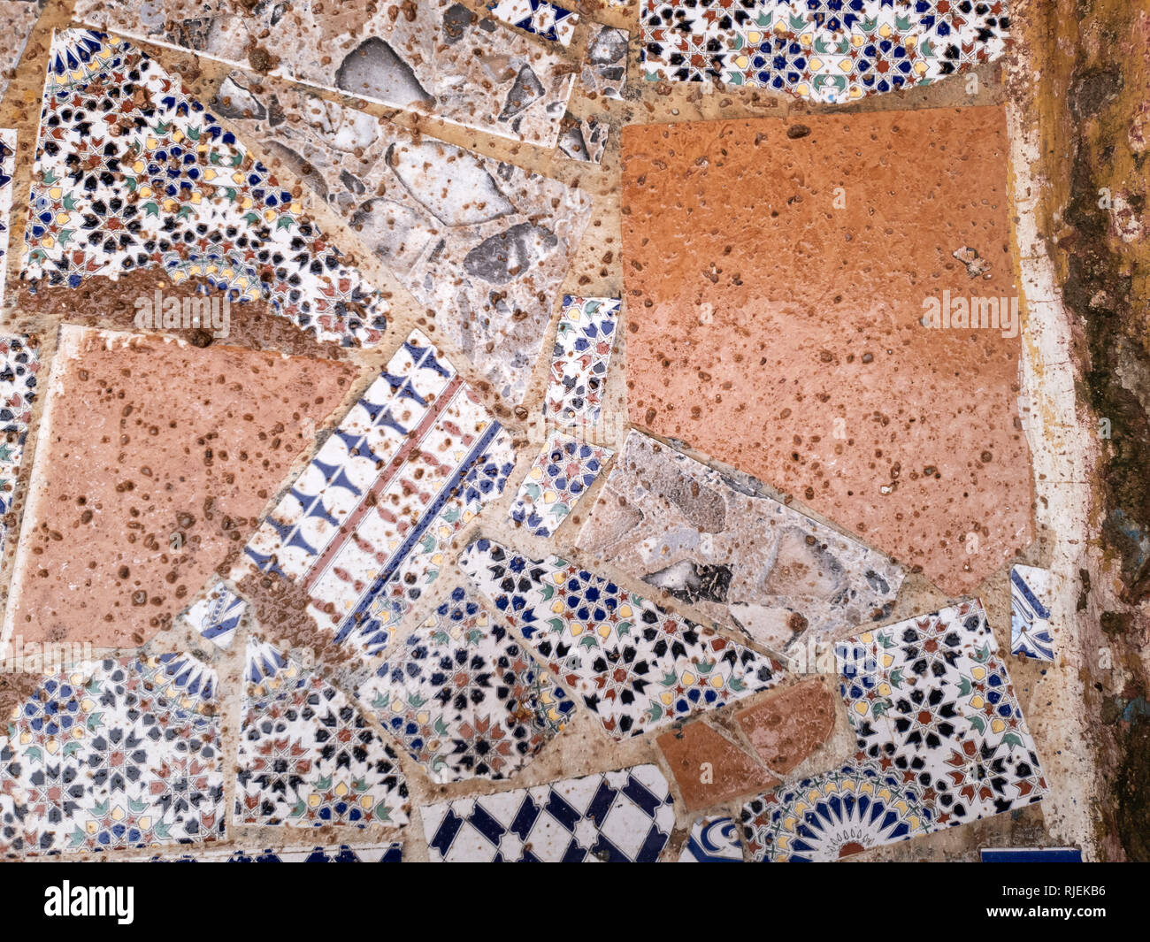 Fragments and uneven fragments of old ceramic tiles in soft brown tones ...