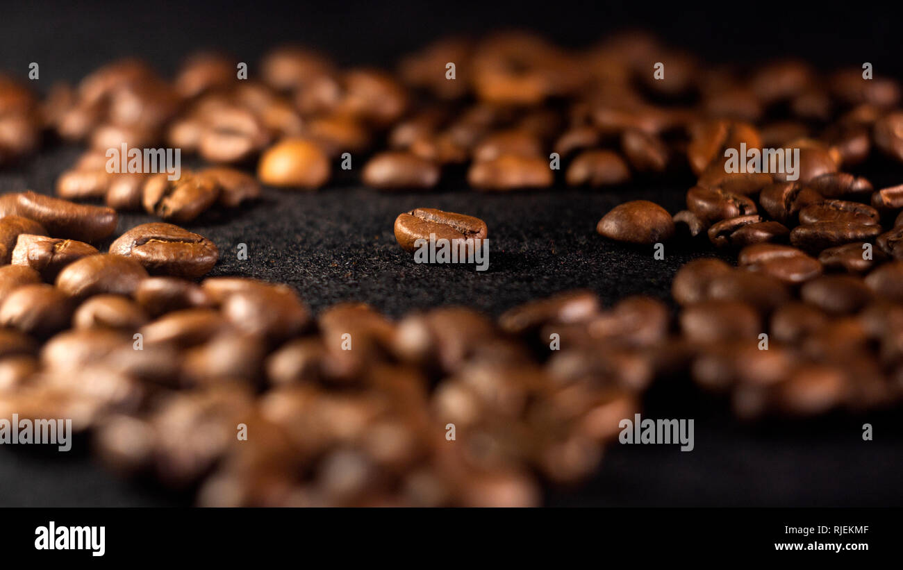 Focus on a single coffee bean on a background of many grains of coffee ...