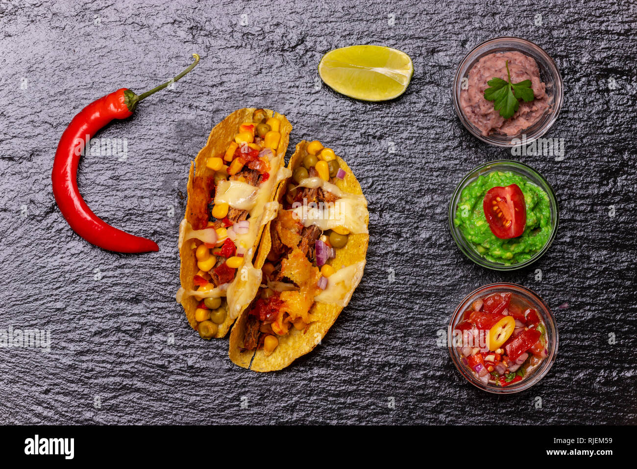 overview of baked tacos with salsa Stock Photo - Alamy