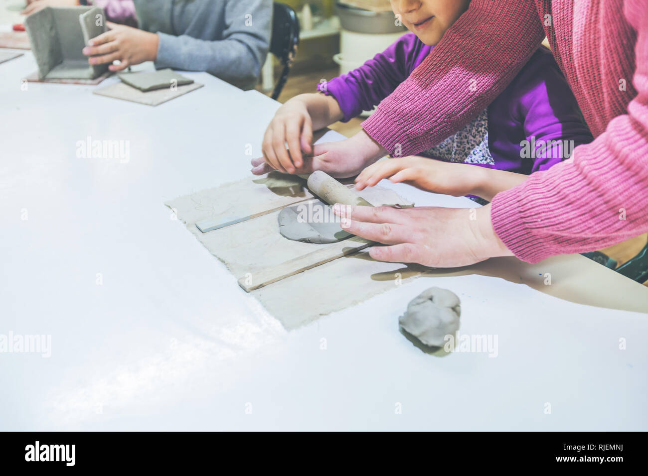 Teacher showing to child how to the working with clay at pottery ...
