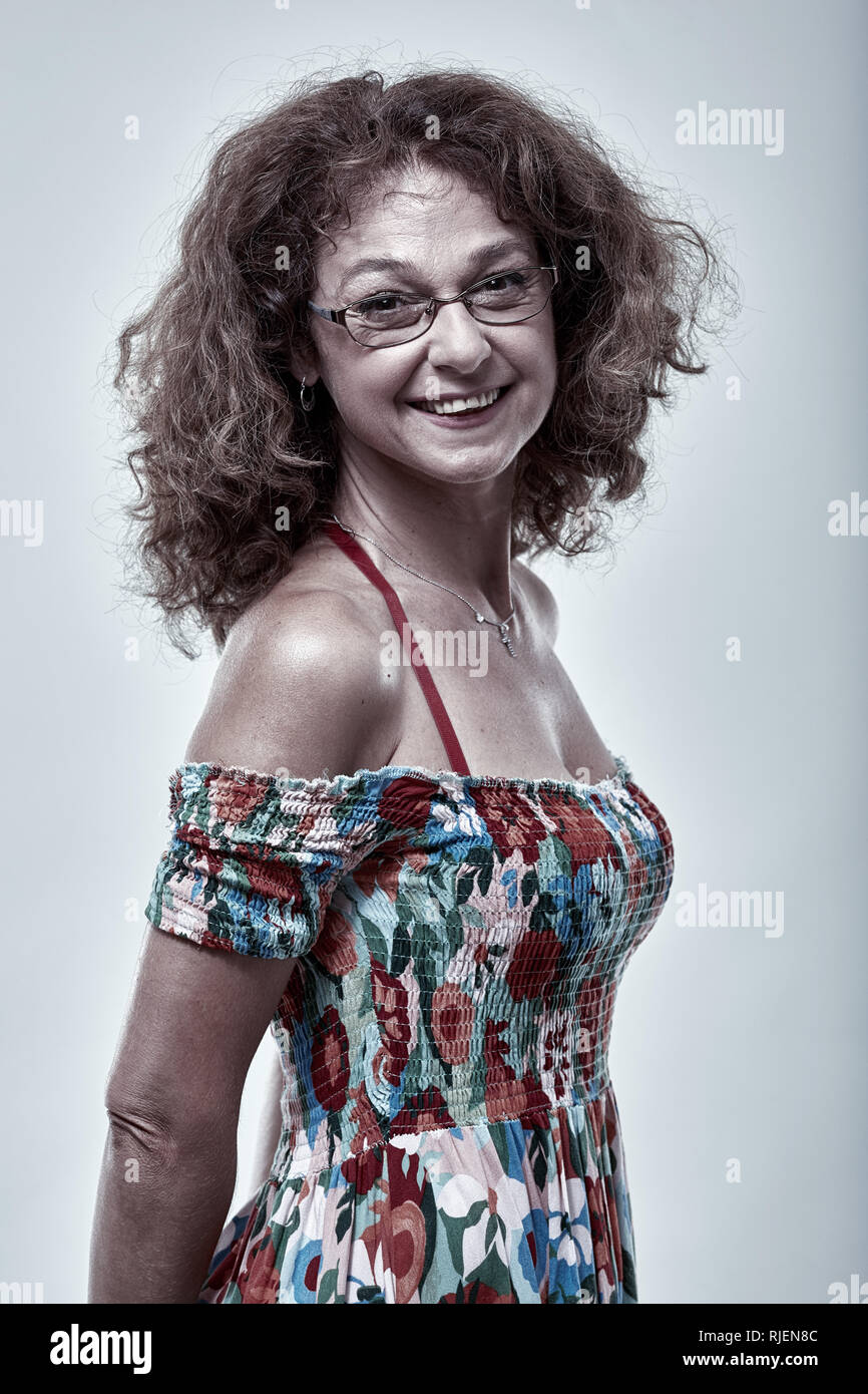 Happy mature woman in her 50s on gray background Stock Photo - Alamy