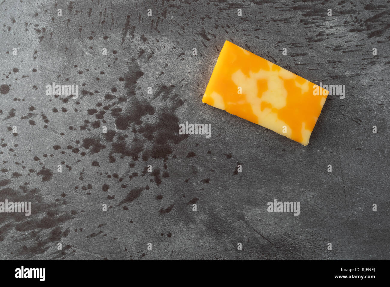 Overhead view of a single Colby Jack cheese bar offset on a gray ...