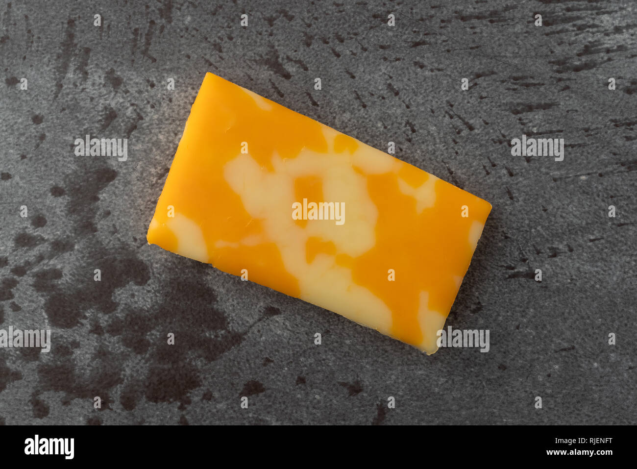 Overhead view of a single Colby Jack cheese bar on a gray background ...