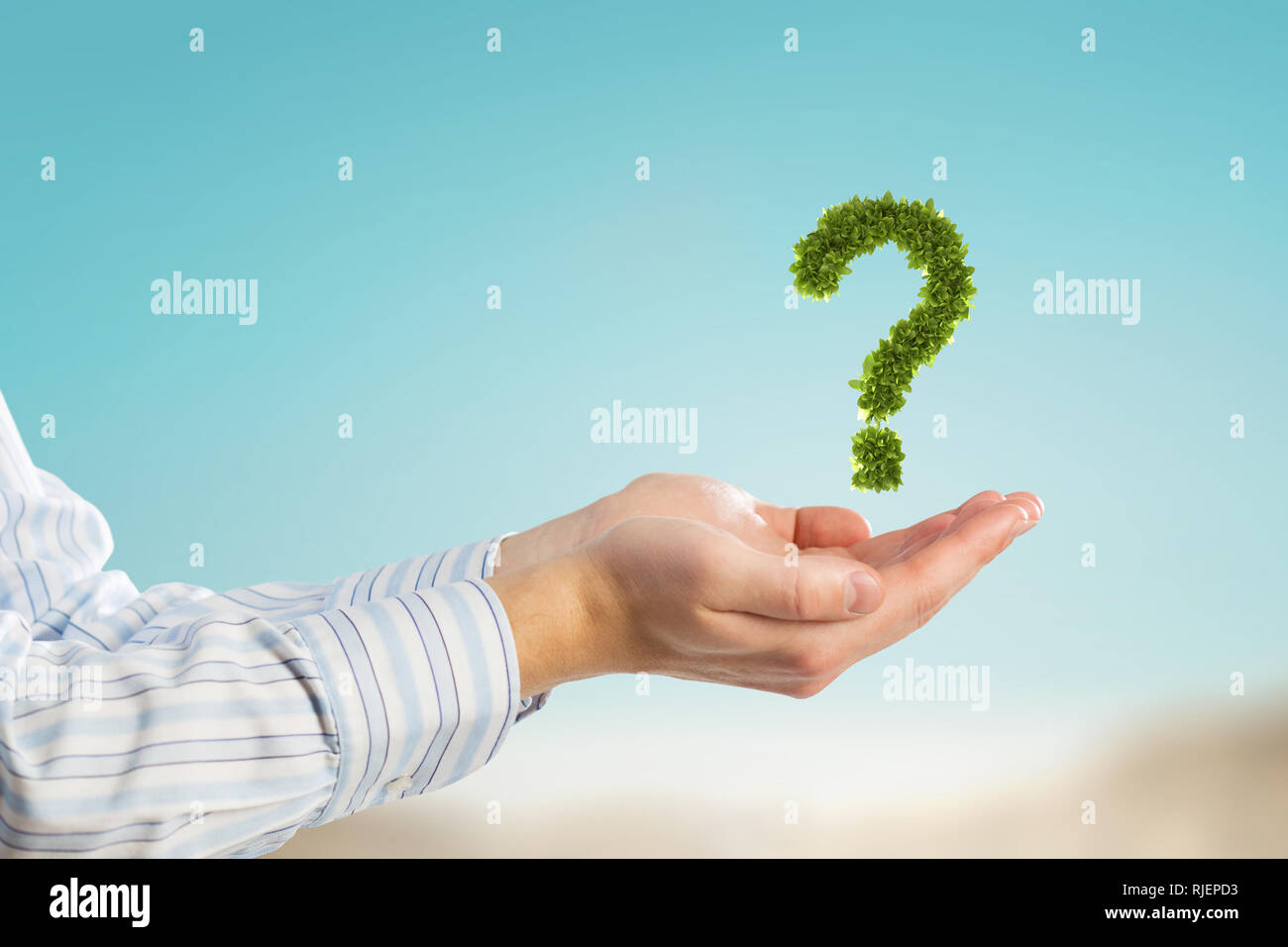 Hands of businessman holding green question mark Stock Photo - Alamy