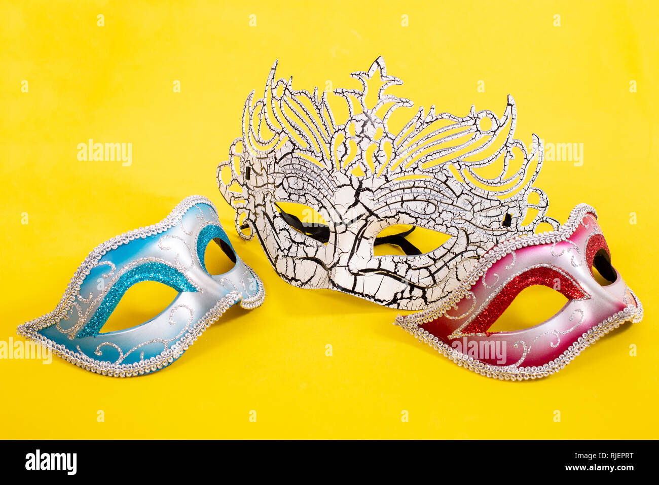 three venetian masks isolated on a yellow background Stock Photo - Alamy