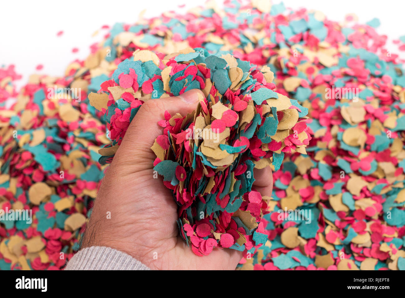 Hand grabs a mix of colorful confetti Stock Photo - Alamy