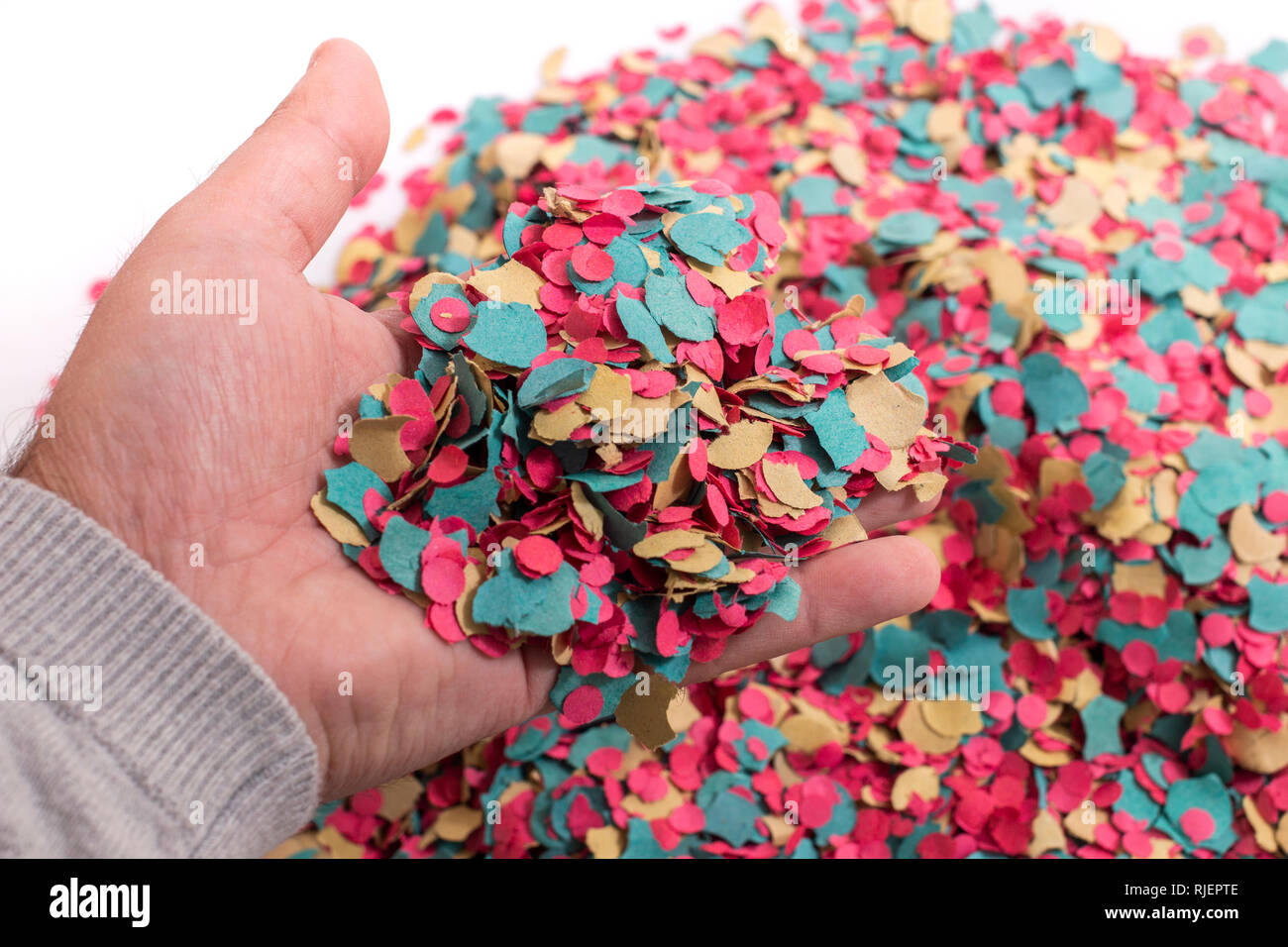 Hand grabs a mix of colorful confetti Stock Photo - Alamy