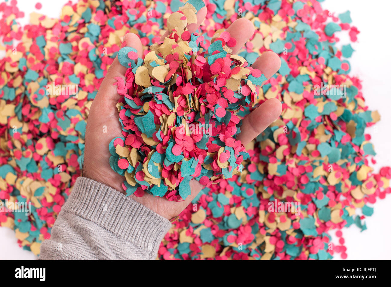 Hand grabs a mix of colorful confetti Stock Photo - Alamy