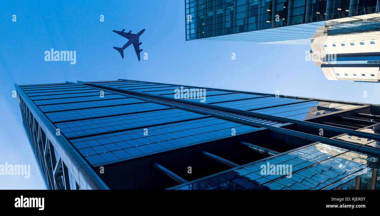 Bottom angle view of airplane in sky over city buildings Stock Photo ...