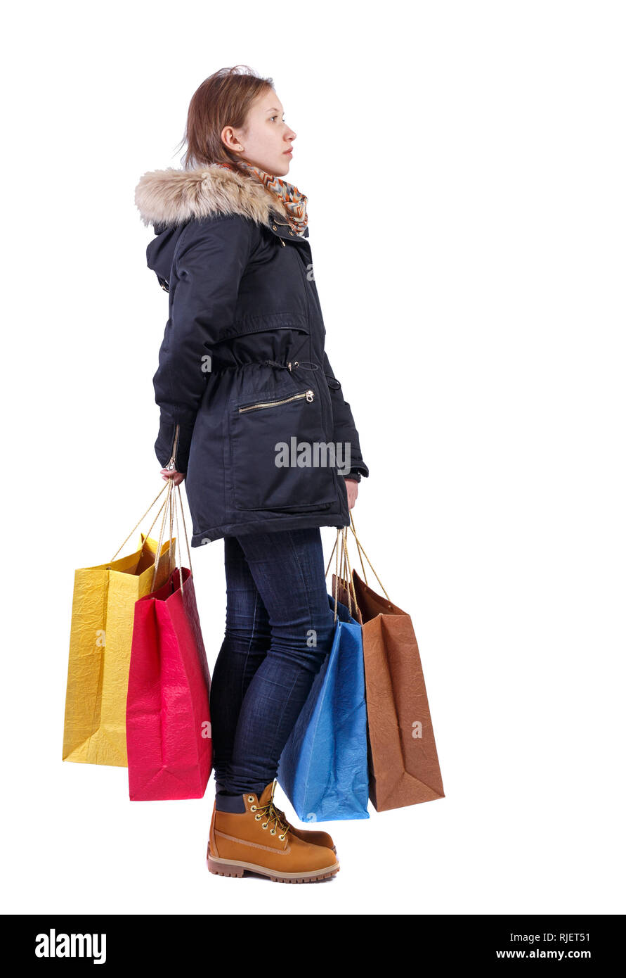 Side view of woman in winter jacket with shopping bags. backside view ...