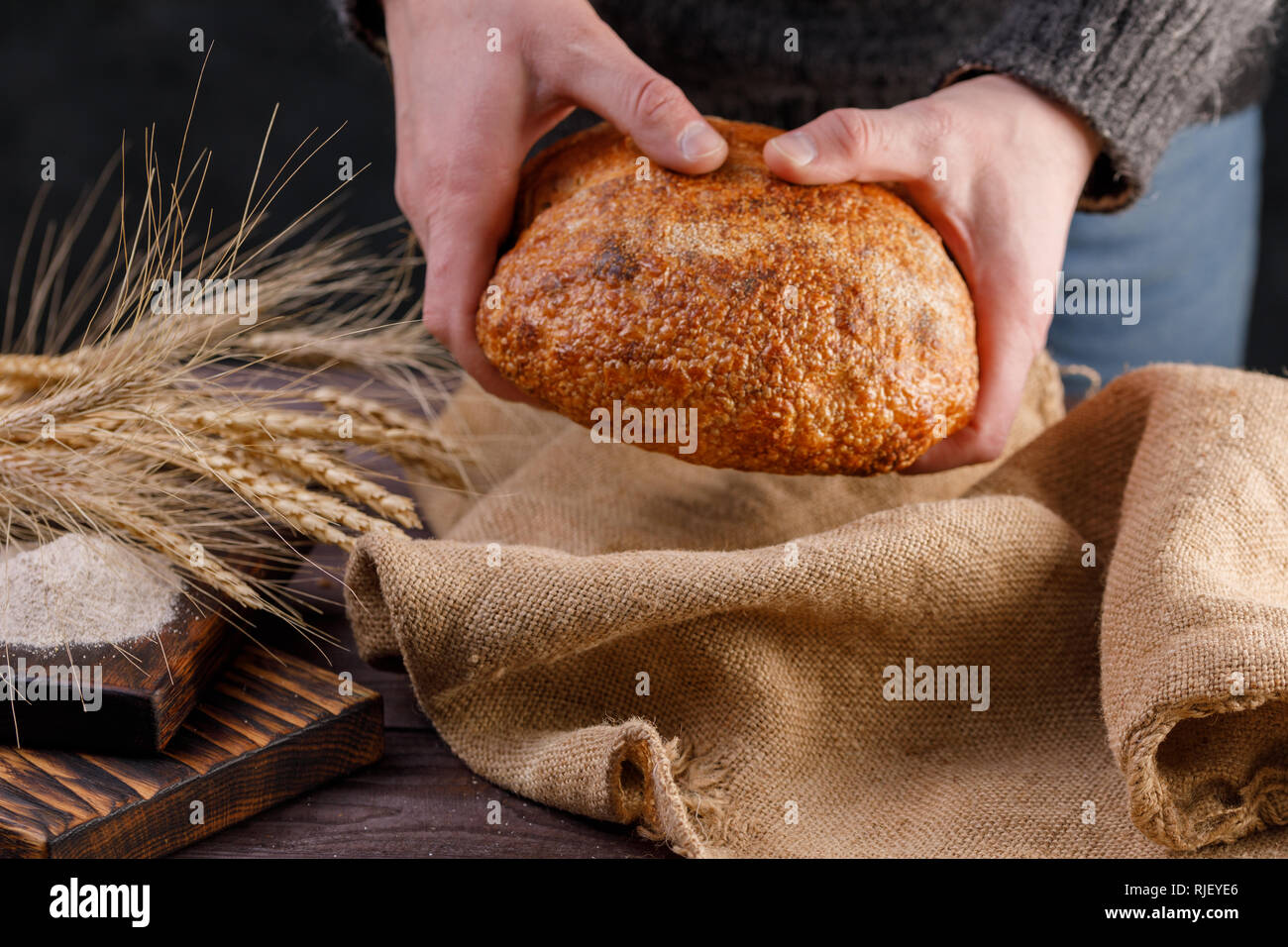Round artisan bread closeup in a man's hand. The concept of healthy ...