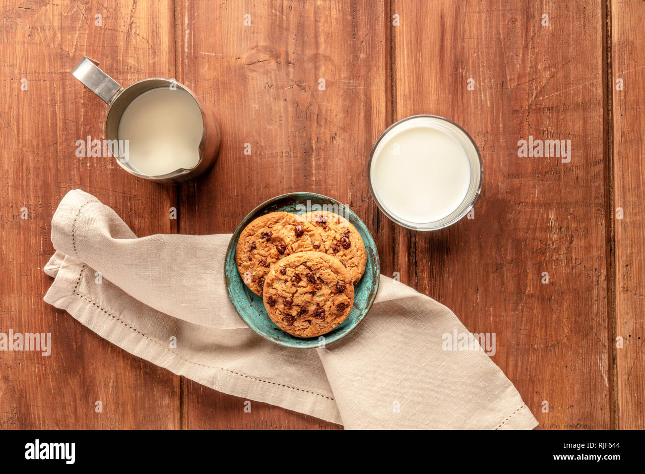 An overhead photo of chocolate chip cookies on a dark rustic wooden ...