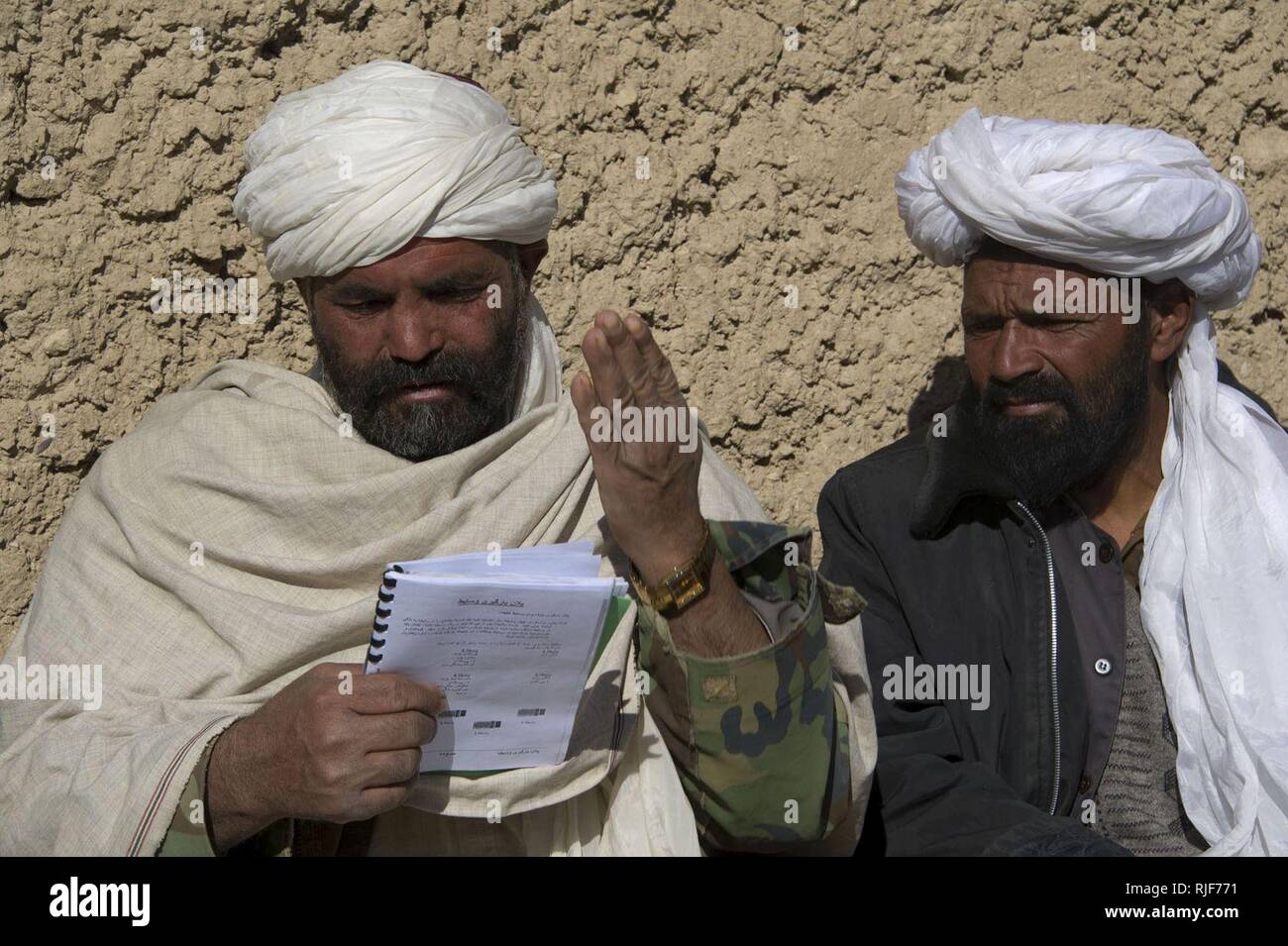 Afghan Local Police candidates study a handbook on basic hand signals ...