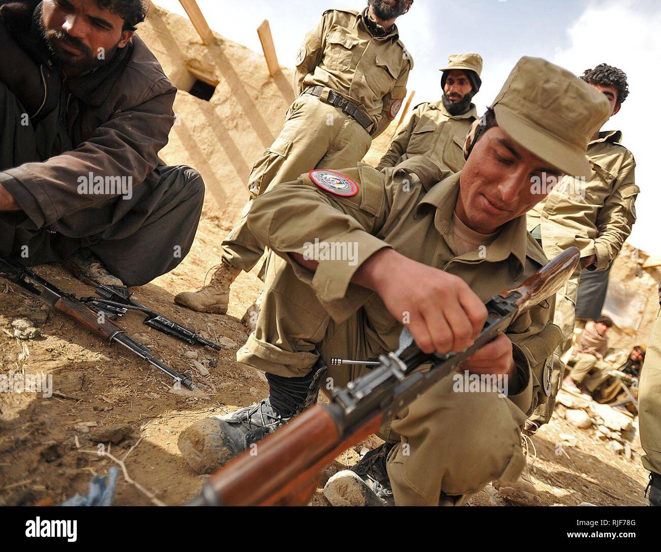 Afghan Local Police recruits practice taking apart an AK-47 rifle ...