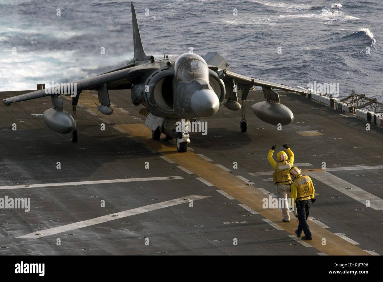 An AV-8B Harrier maneuvers into takeoff position on the flight deck of ...
