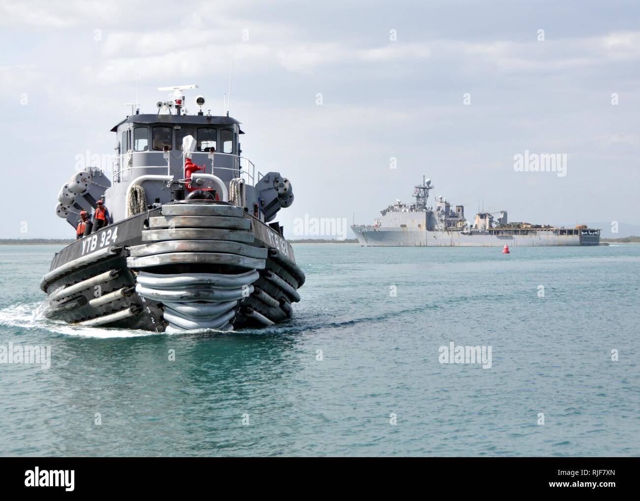U.S. Navy harbor tug boat Santaquin pulls into the pier while the ...