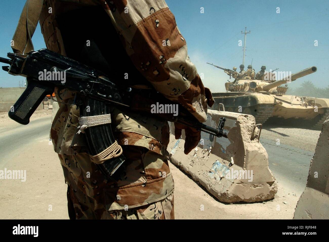 An Iraqi army soldier stands guard duty while Iraqi army soldiers from ...