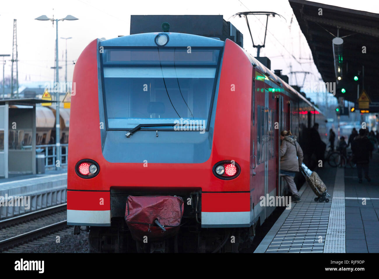 red passenger train in a station Stock Photo - Alamy