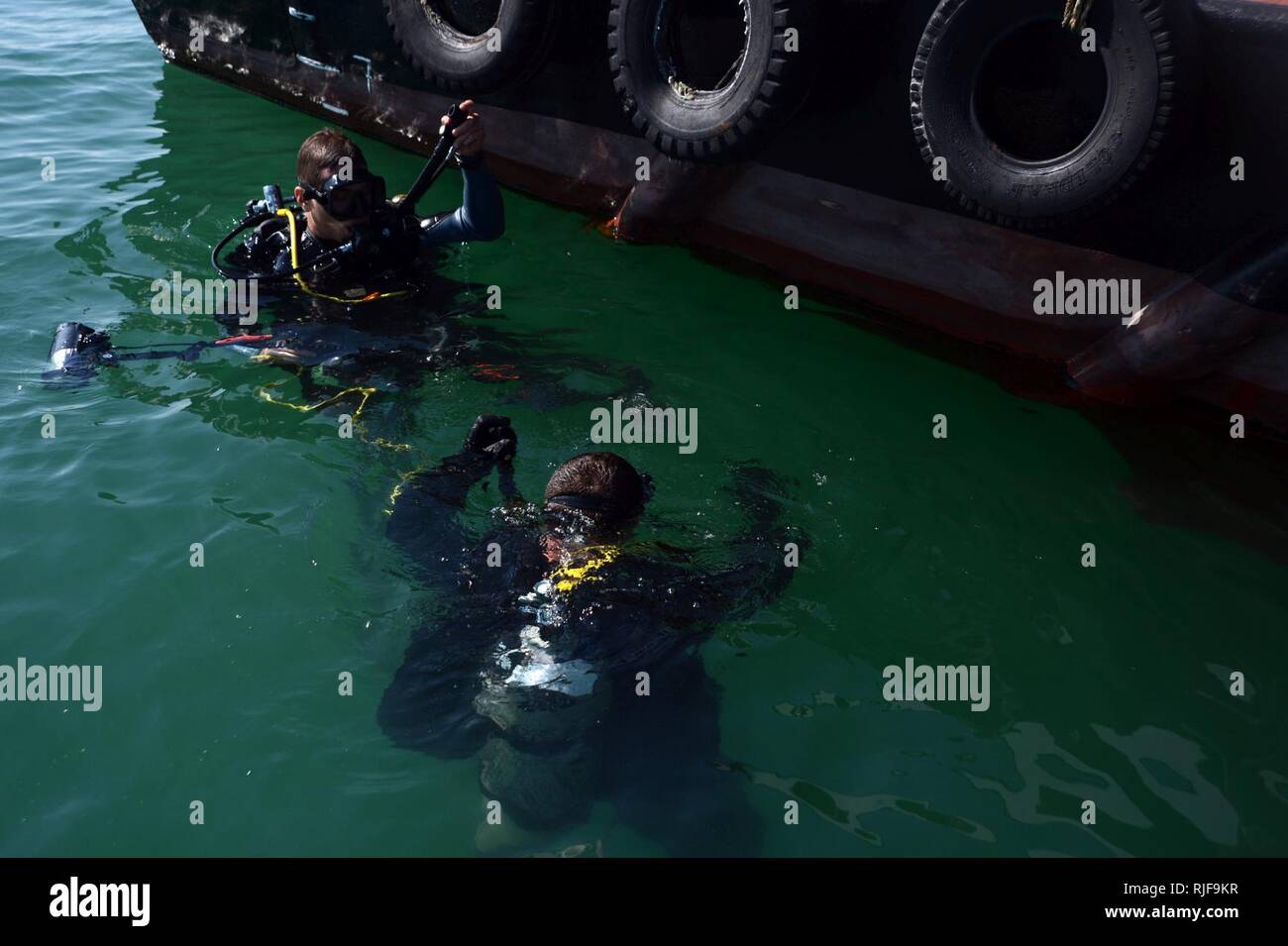 Navy Diver 2nd Class Steven Starner, bottom, assigned to Mobile Diving ...