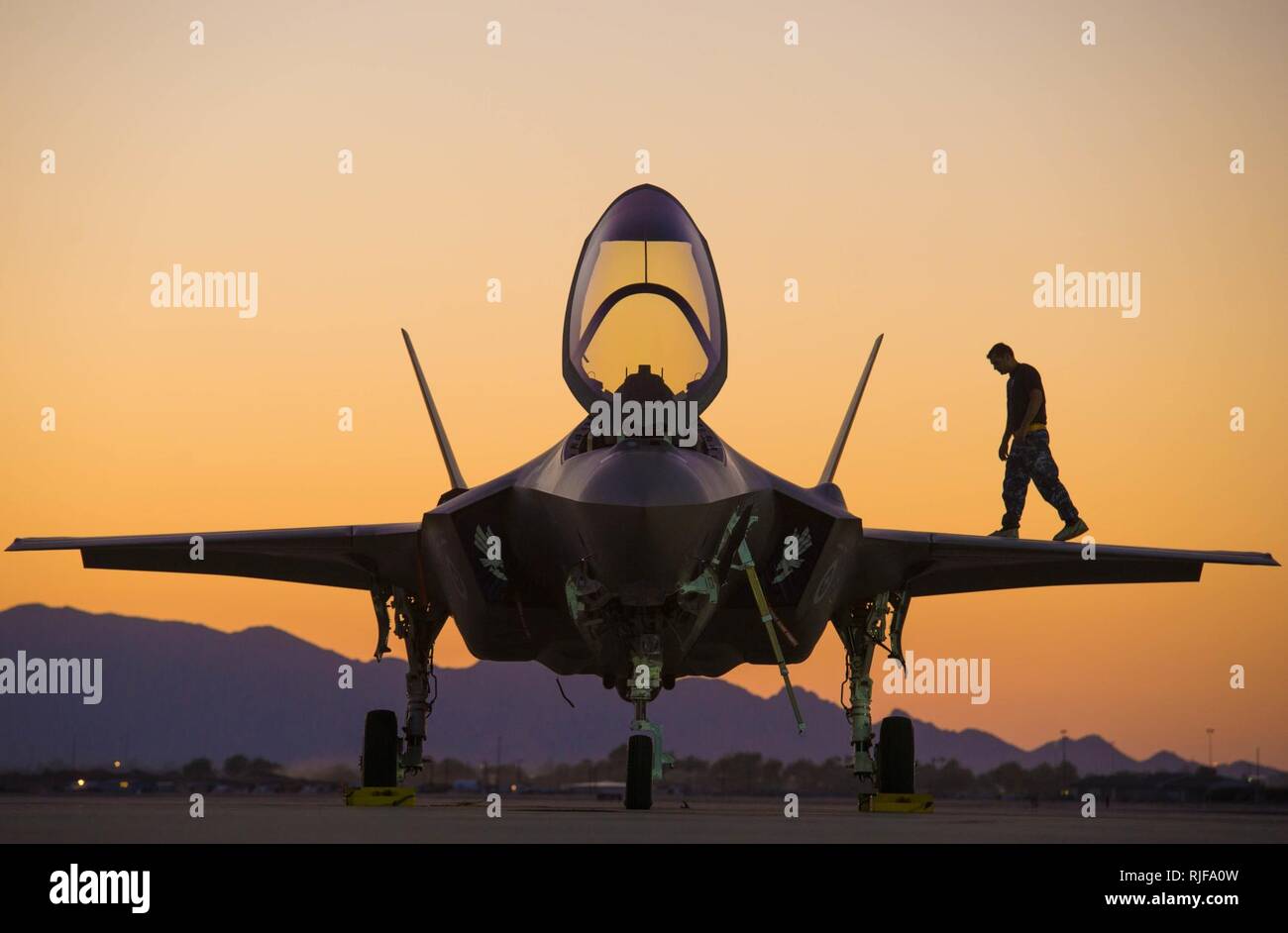 A Royal Australian Air Force Airman walks on the wing of an F-35A ...