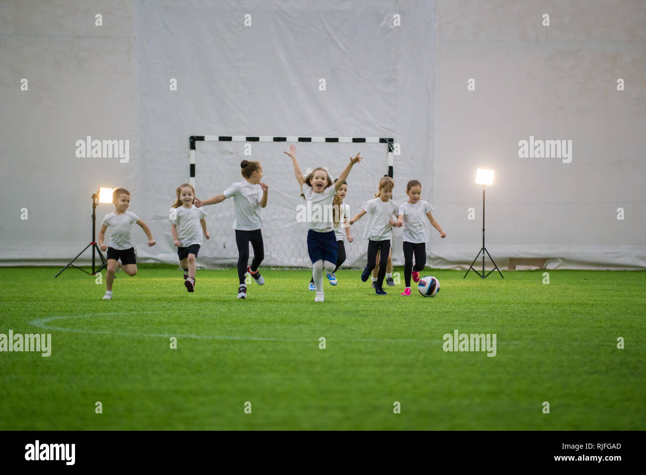 Little kids playing football indoors. Children football team running on ...