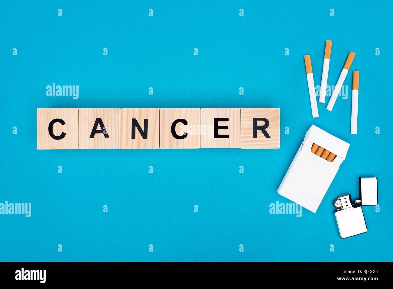 Flat lay of cigarettes and wooden cubes with text isolated on blue ...
