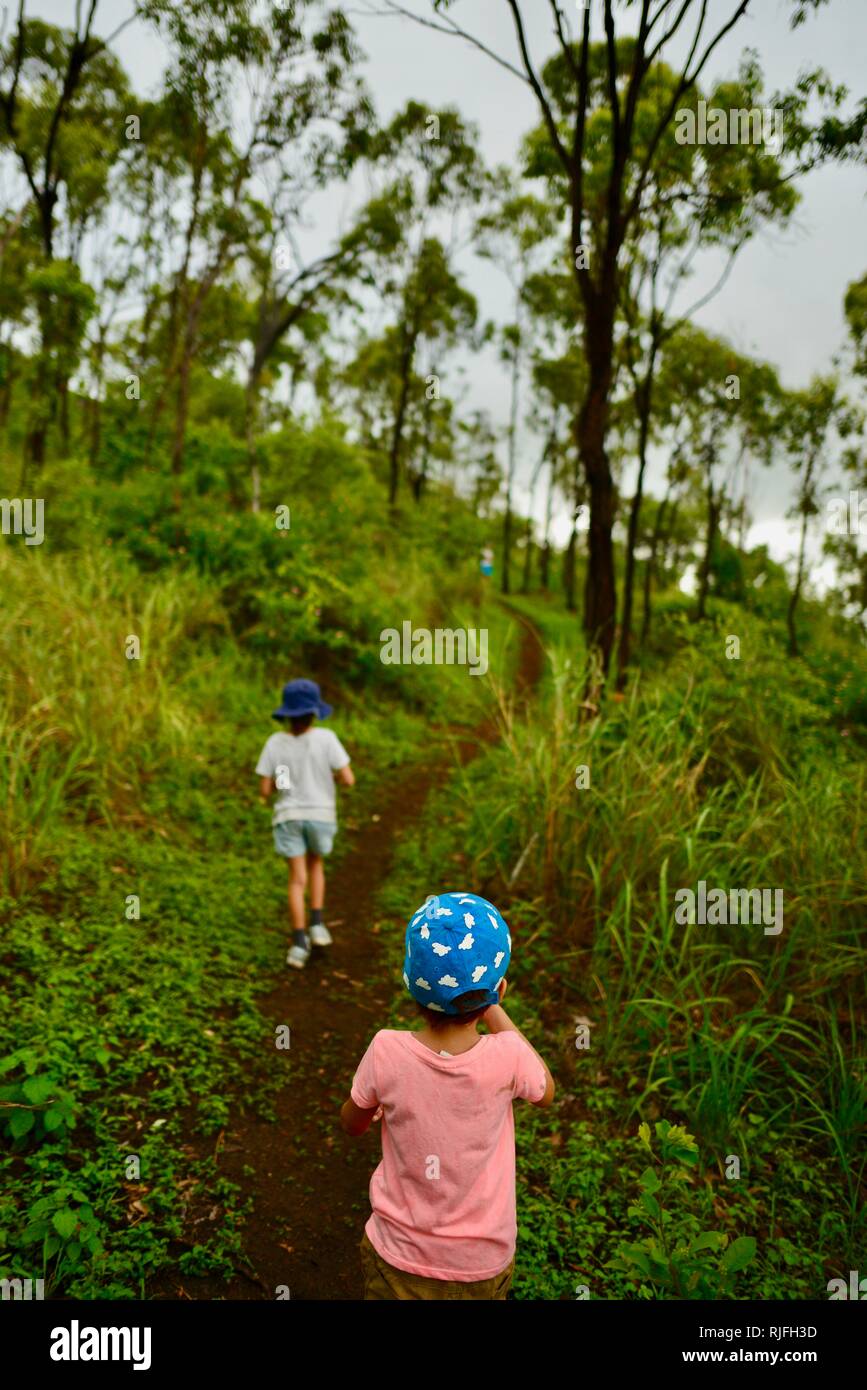 Young school age children walking along a dirt track, Moongun walking ...