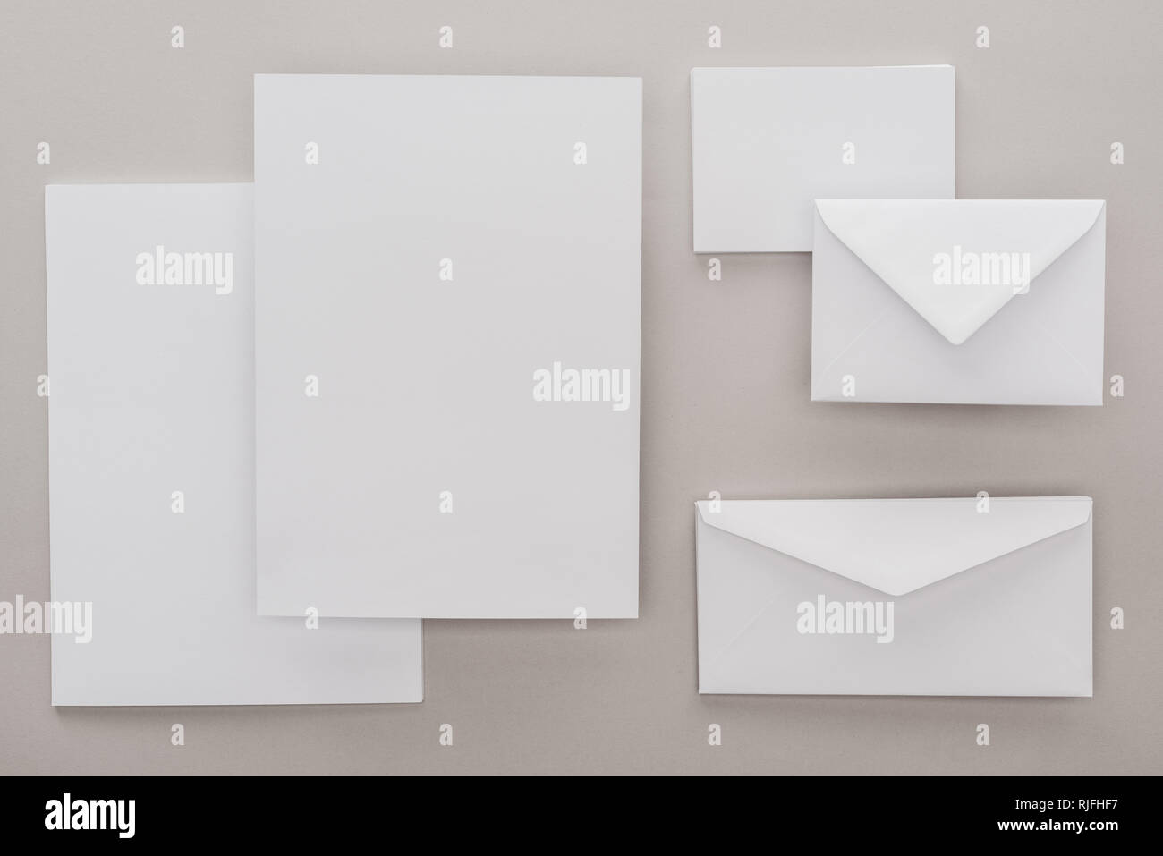 flat lay with white blank papers and envelopes on grey background Stock ...