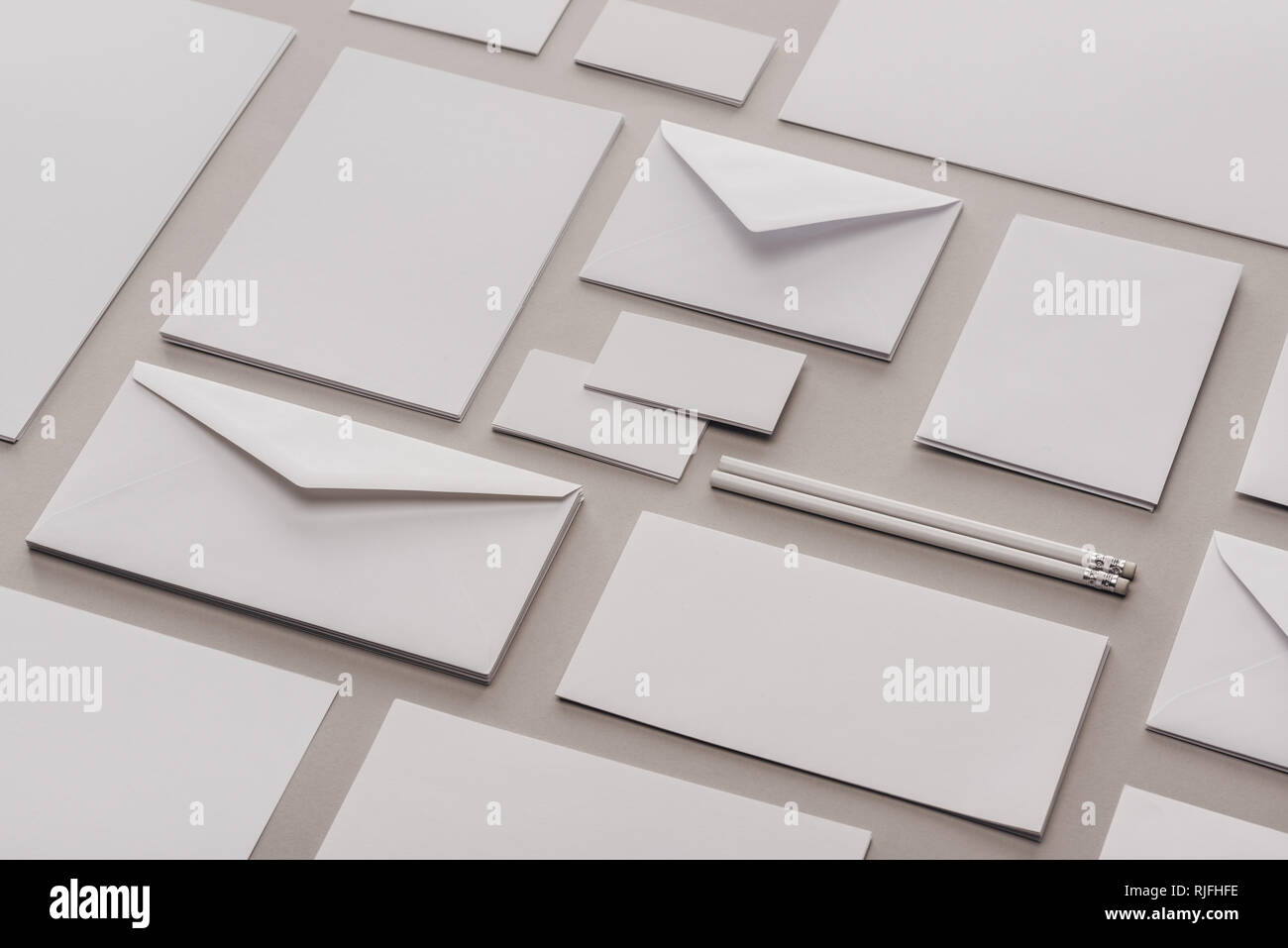 Flat lay with white pencils, envelopes, empty cards and sheets of paper ...